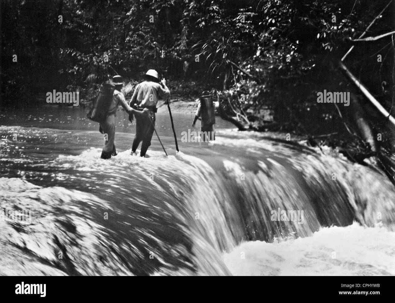 Jungle explorers crossing a river, 1935 Stock Photo - Alamy
