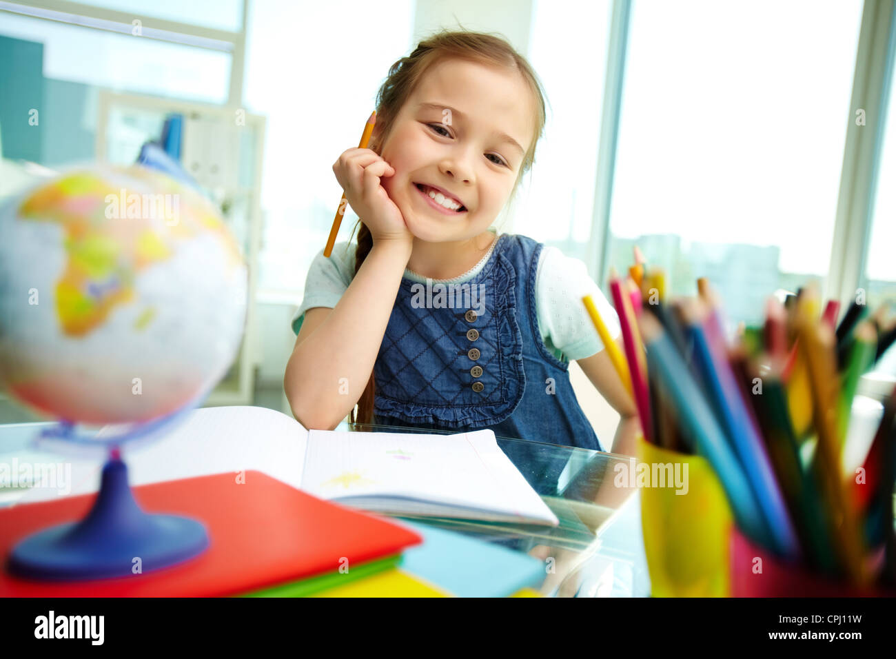 Portrait of lovely girl looking at camera while drawing Stock Photo - Alamy