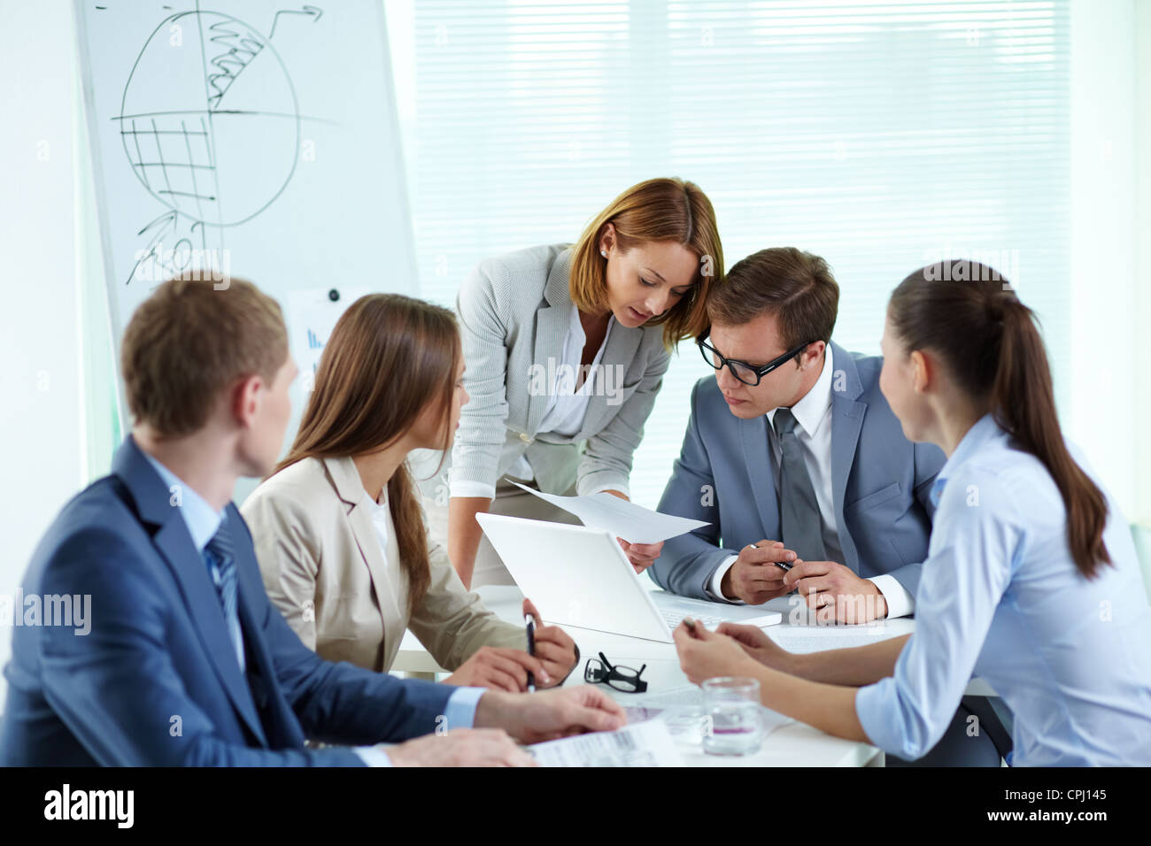 Image of confident partners discussing paper at meeting Stock Photo - Alamy