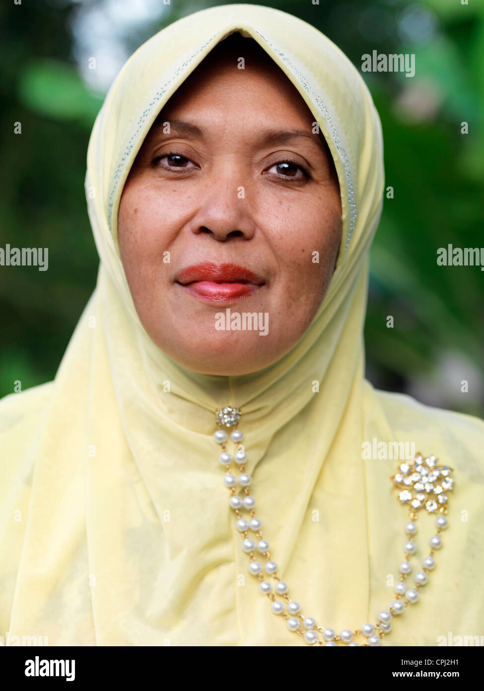 A portrait of an ethnic Bugis Malaysian woman standing in a garden ...