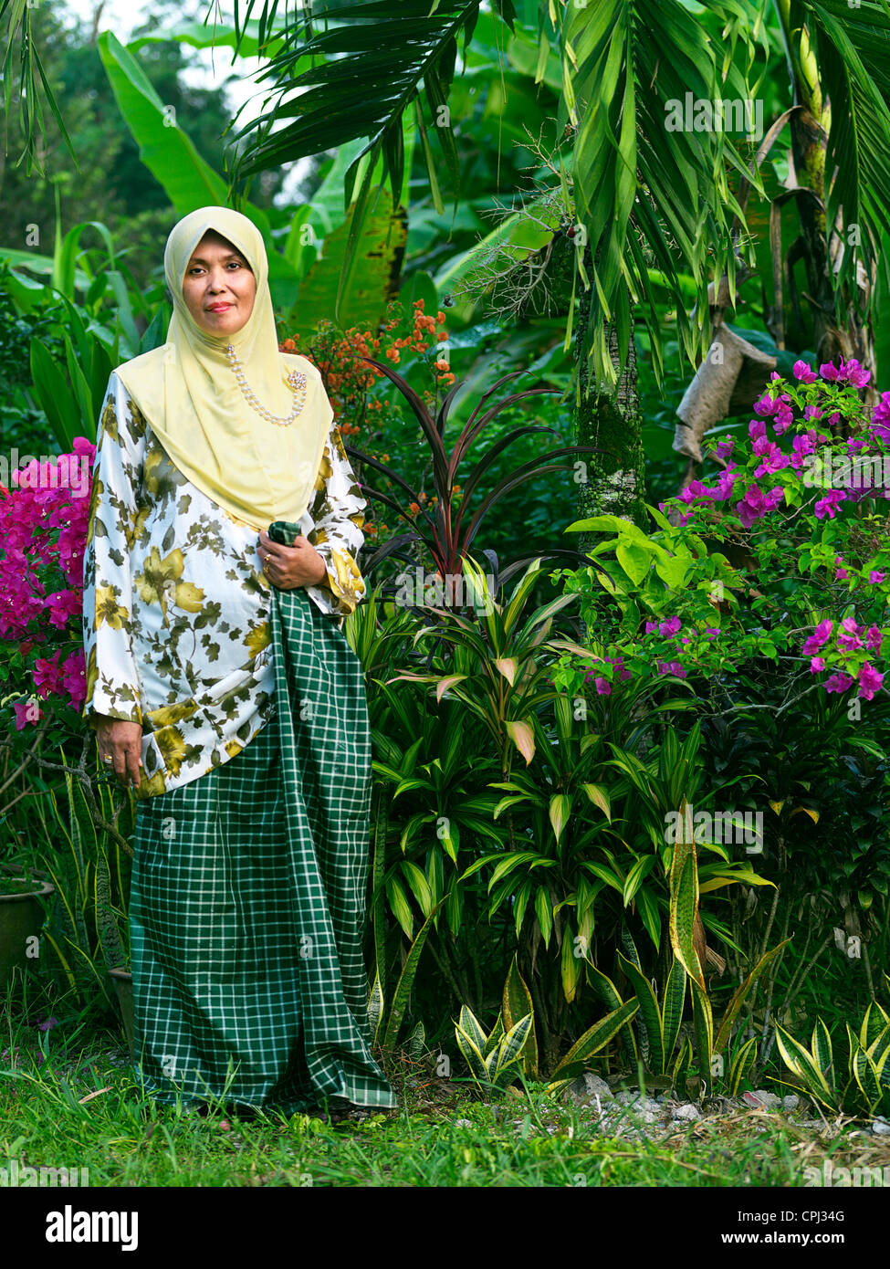 A portrait of an ethnic Bugis Malaysian woman standing in a garden ...