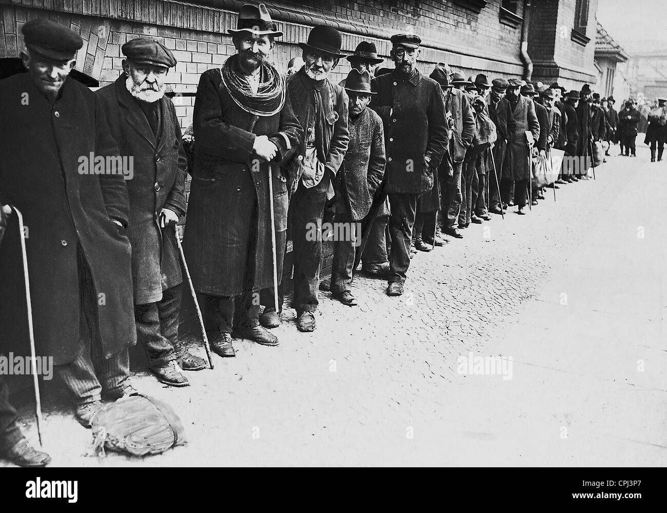 Homeless people waiting outside a shelter in Berlin, 1924 Stock Photo ...