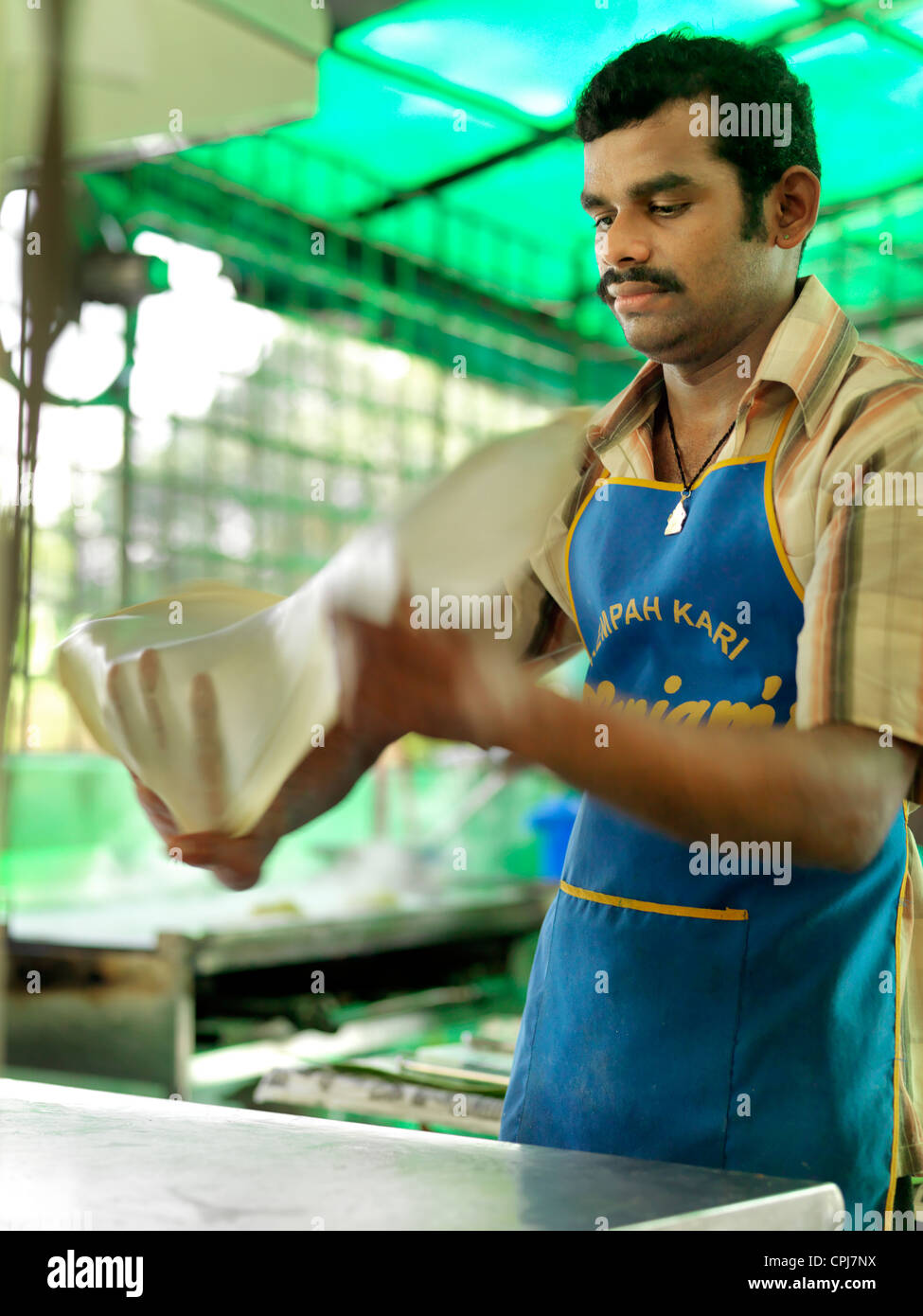 A street vendor preparing traditional Indian Roti Canai flatbread Stock ...