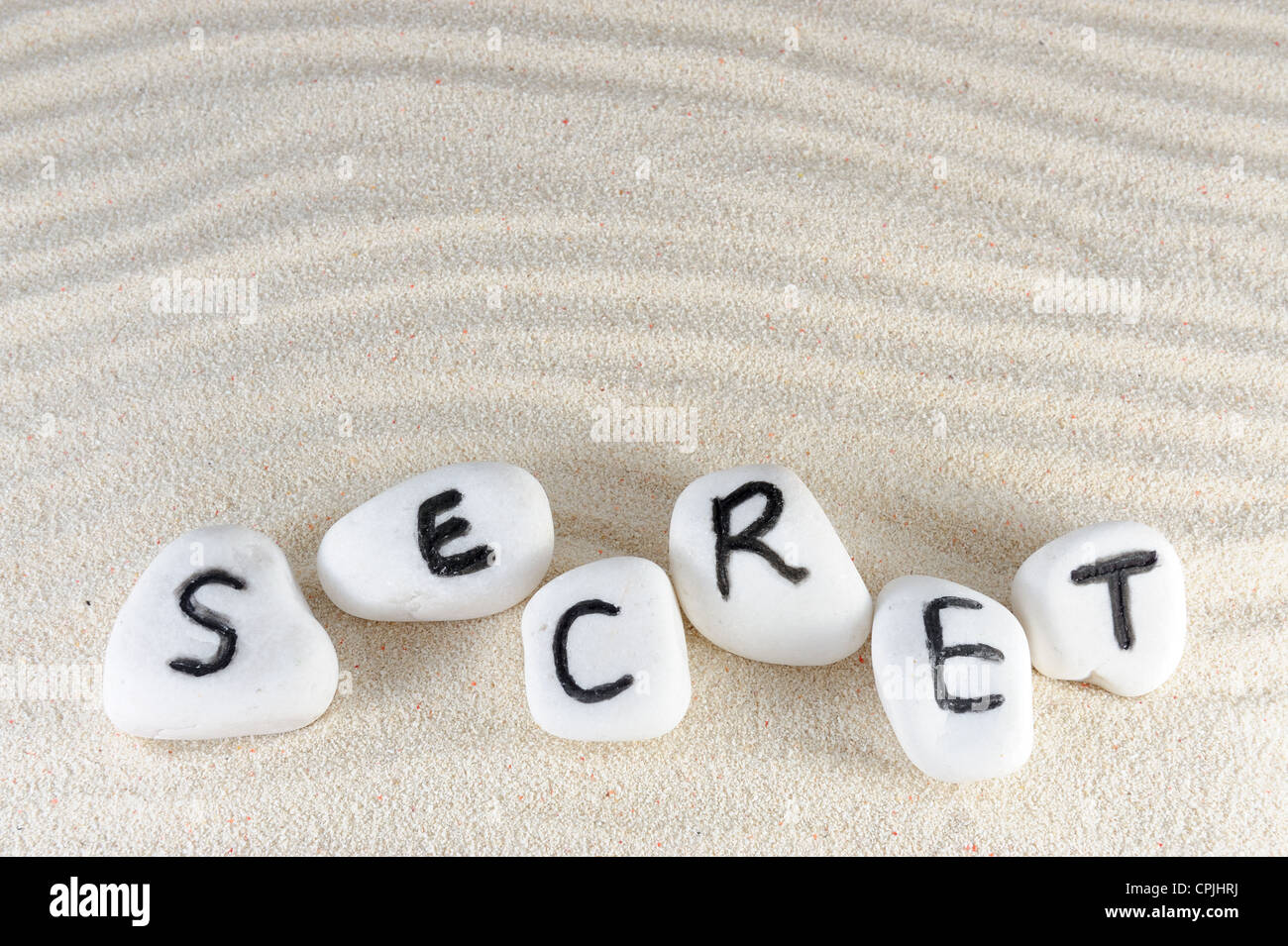 Secret word on group of stones with sand as background Stock Photo - Alamy