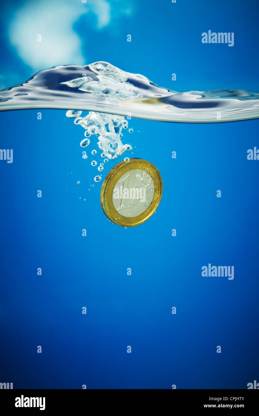 1 Euro Coin sinking in blue water Stock Photo - Alamy