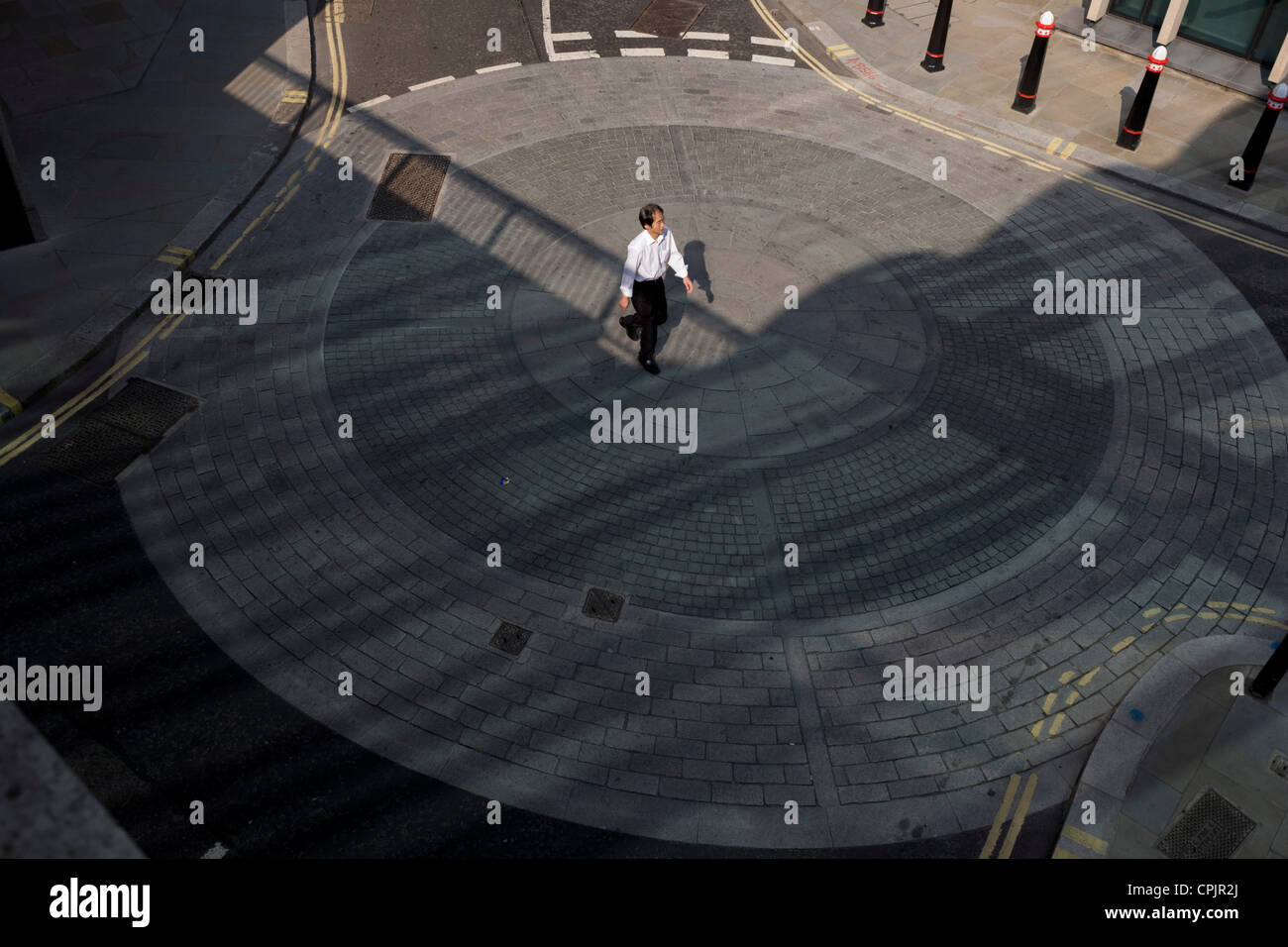 A lone pedestrian over the centre of a mini-roundabout in a City of ...
