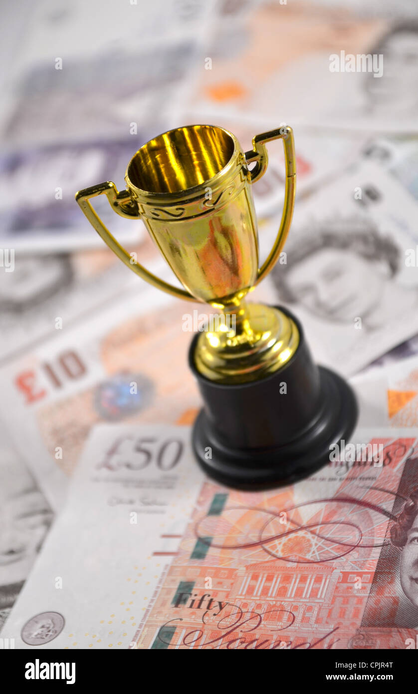 Small trophy cup on pound notes Stock Photo - Alamy