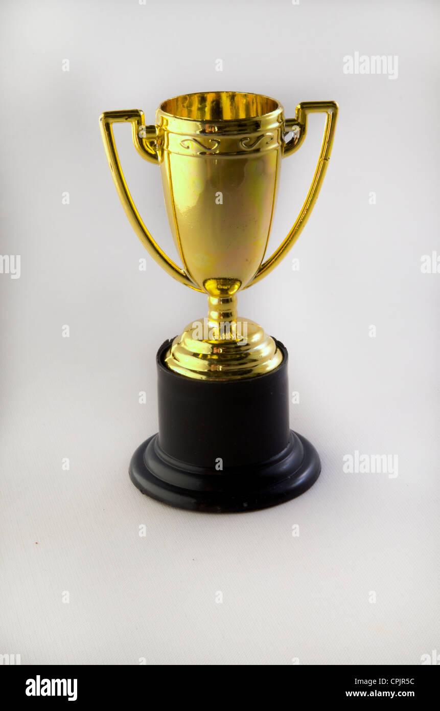 Small toy trophy on white background Stock Photo - Alamy