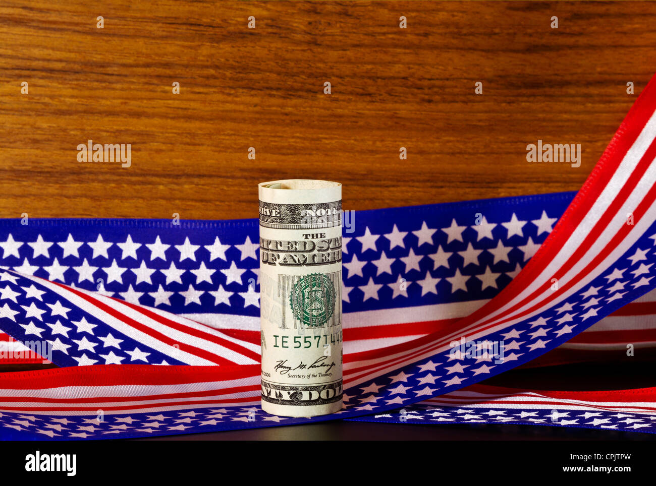 American currency placed in front of stars and stripes ribbon that ...