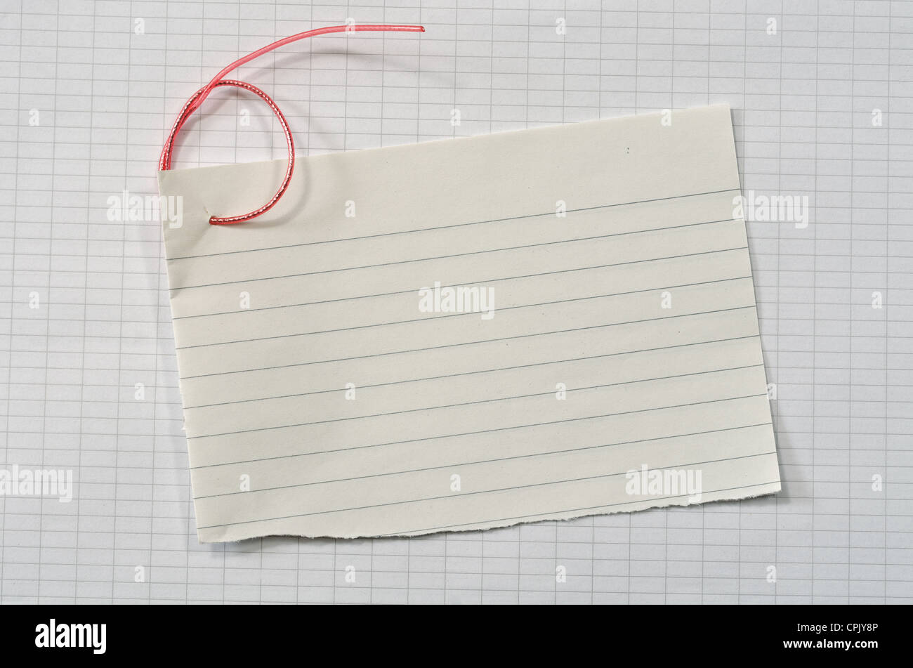 torn lined paper with red wire in shape of number six over data paper ...