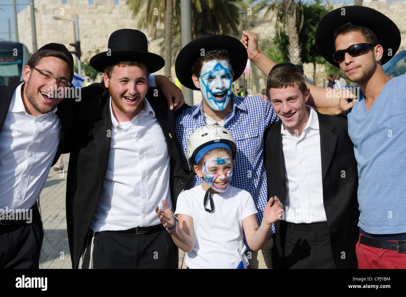 Young man with an Israeli flag painted on his face pausing with people ...