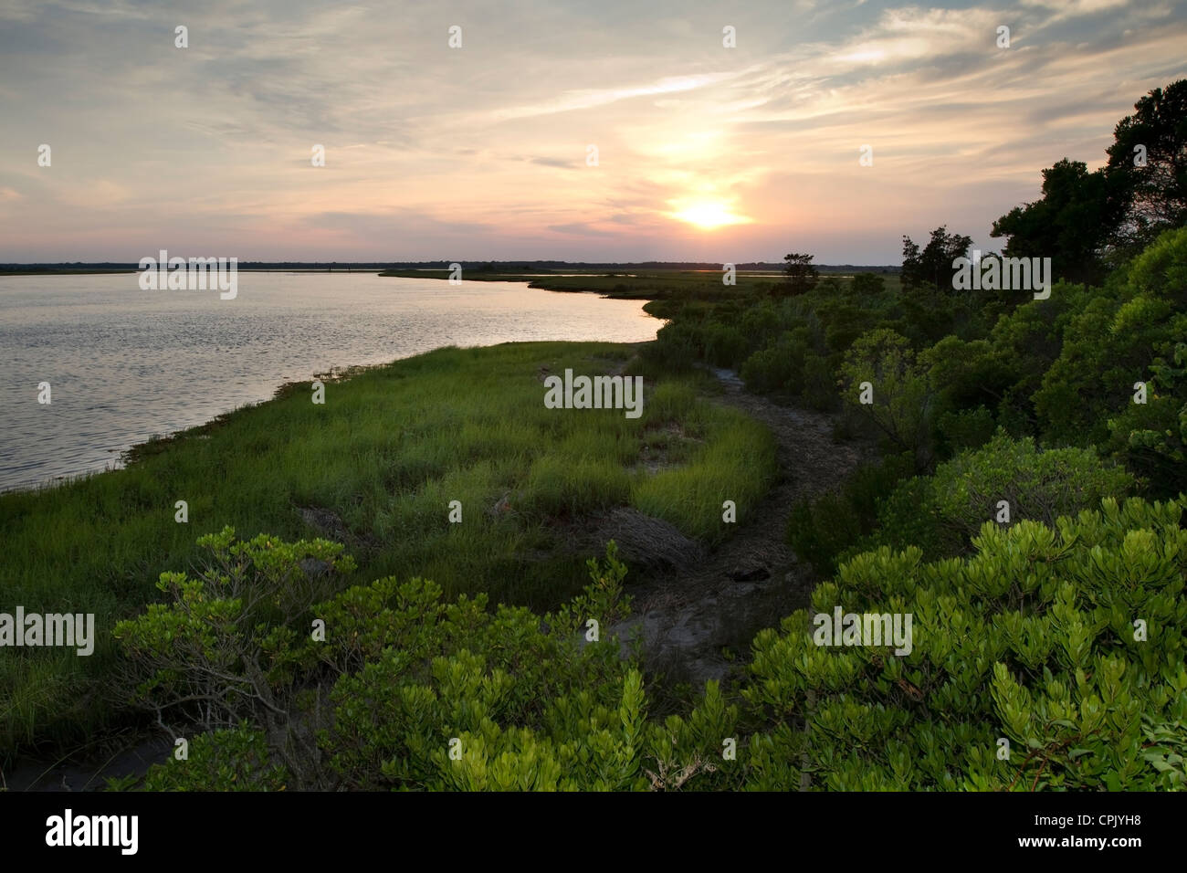 reflecting light clouds and grassy inlet sunset Stock Photo - Alamy