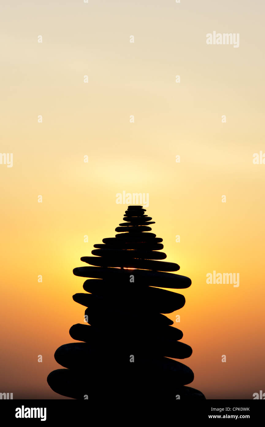 Stacked pebbles silhouette against a sunset. UK Stock Photo - Alamy