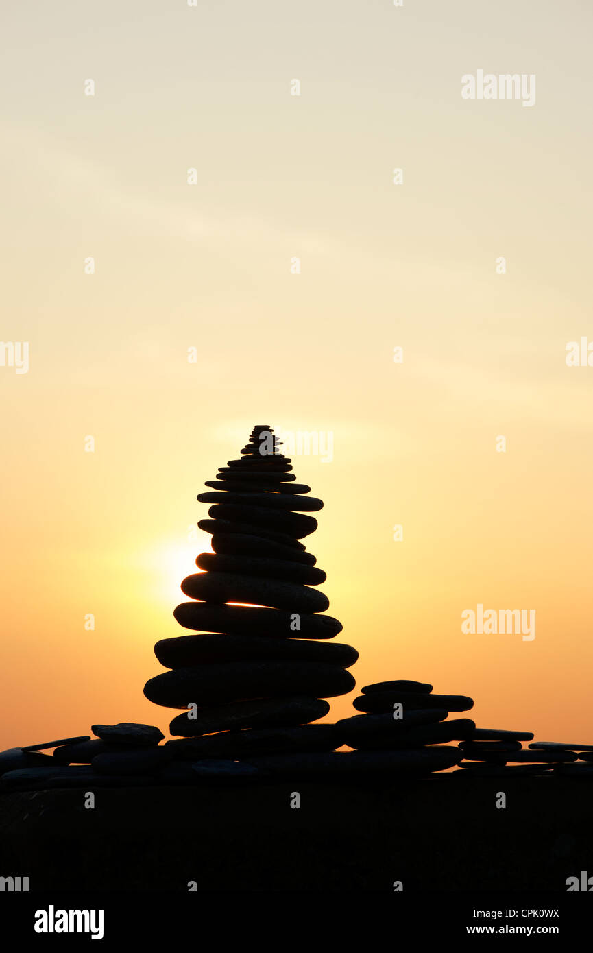 Stacked pebbles silhouette against a sunset. UK Stock Photo - Alamy