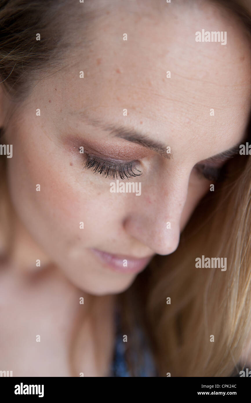 Close up of a woman looking down with serious expression Stock Photo ...