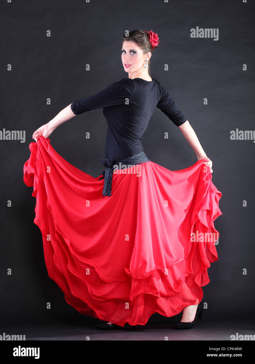 Attractive spanish dancer over black background young woman dancing ...
