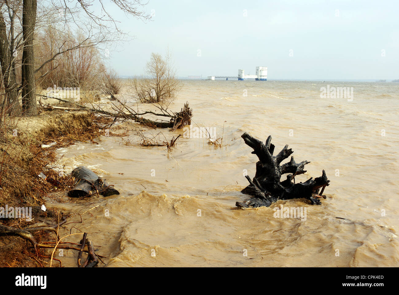 Volga River, spring flood water and wave erodes ashore. Garbage on the ...