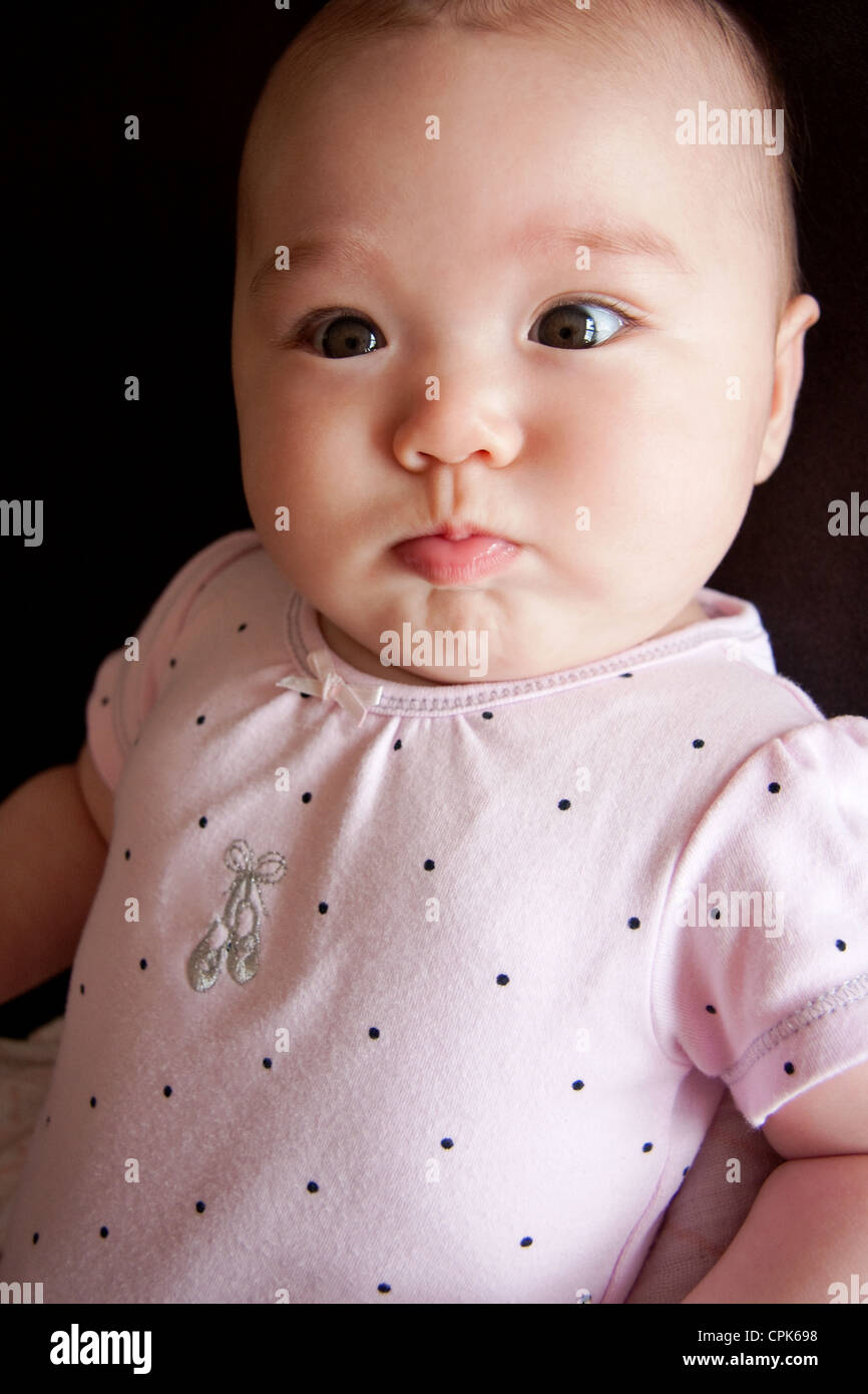 Baby girl making funny face Stock Photo - Alamy