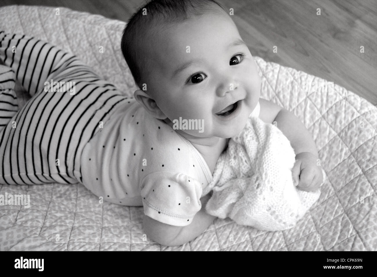 Laughing baby on her tummy b&w Stock Photo - Alamy