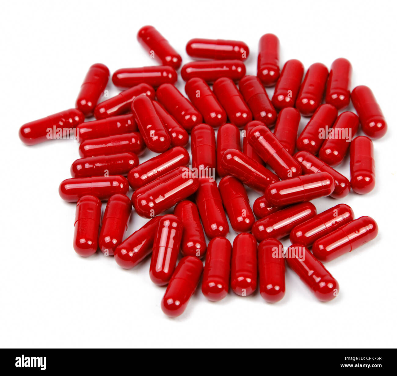 Red capsules upper view over white background Stock Photo - Alamy