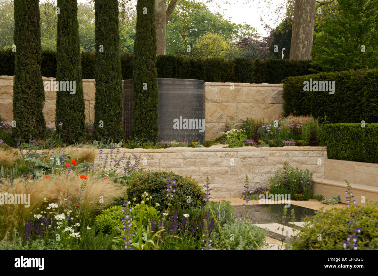 A view of the water cascade, cypress trees and planting in the ...