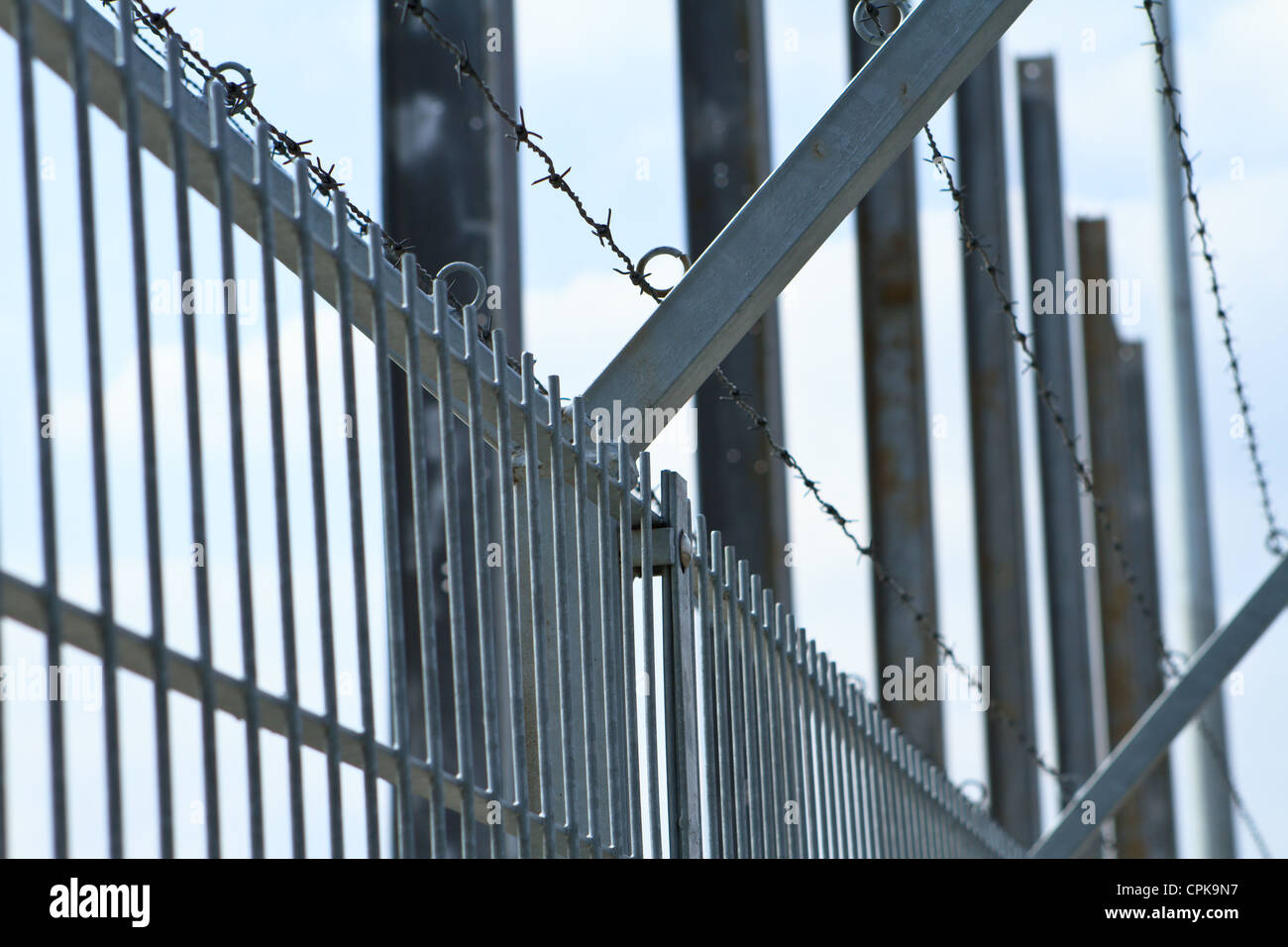Barbed wire and security fence Stock Photo - Alamy