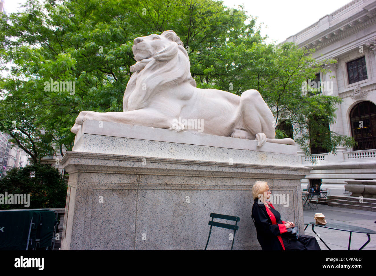 A stone lion stands guard in front of the New York Public Library on ...