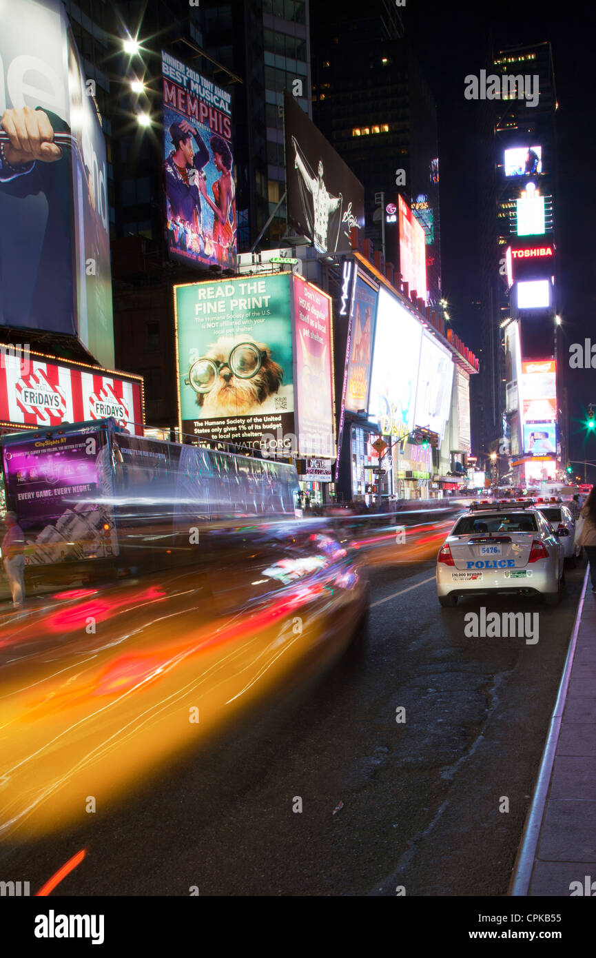 Cars & iconic yellow cabs & taxis speeding at night through Times ...