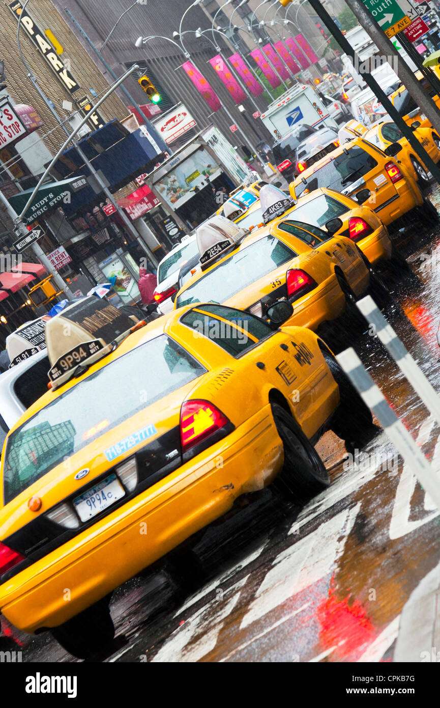 Iconic yellow taxis of New York lined up in traffic, typical transport ...