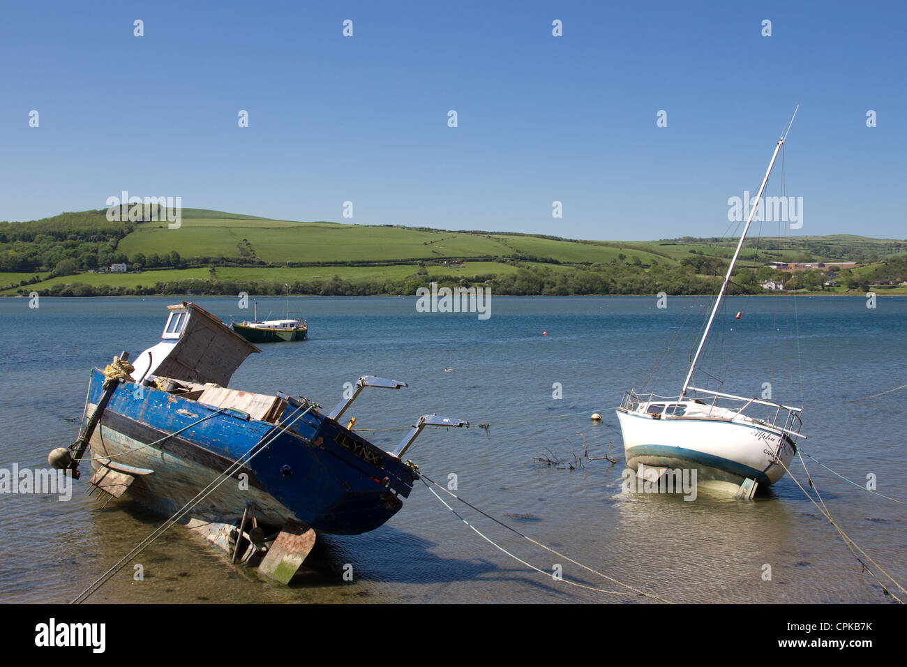 Low tide near Gwbert, with moored boats leaning to one side Stock Photo ...