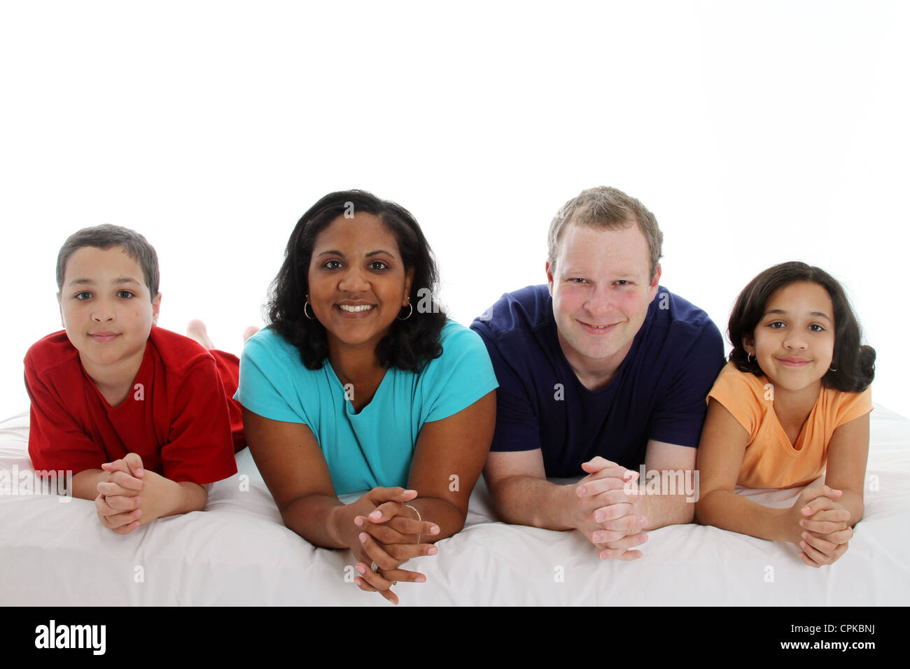 Family laying down together on a bed Stock Photo - Alamy