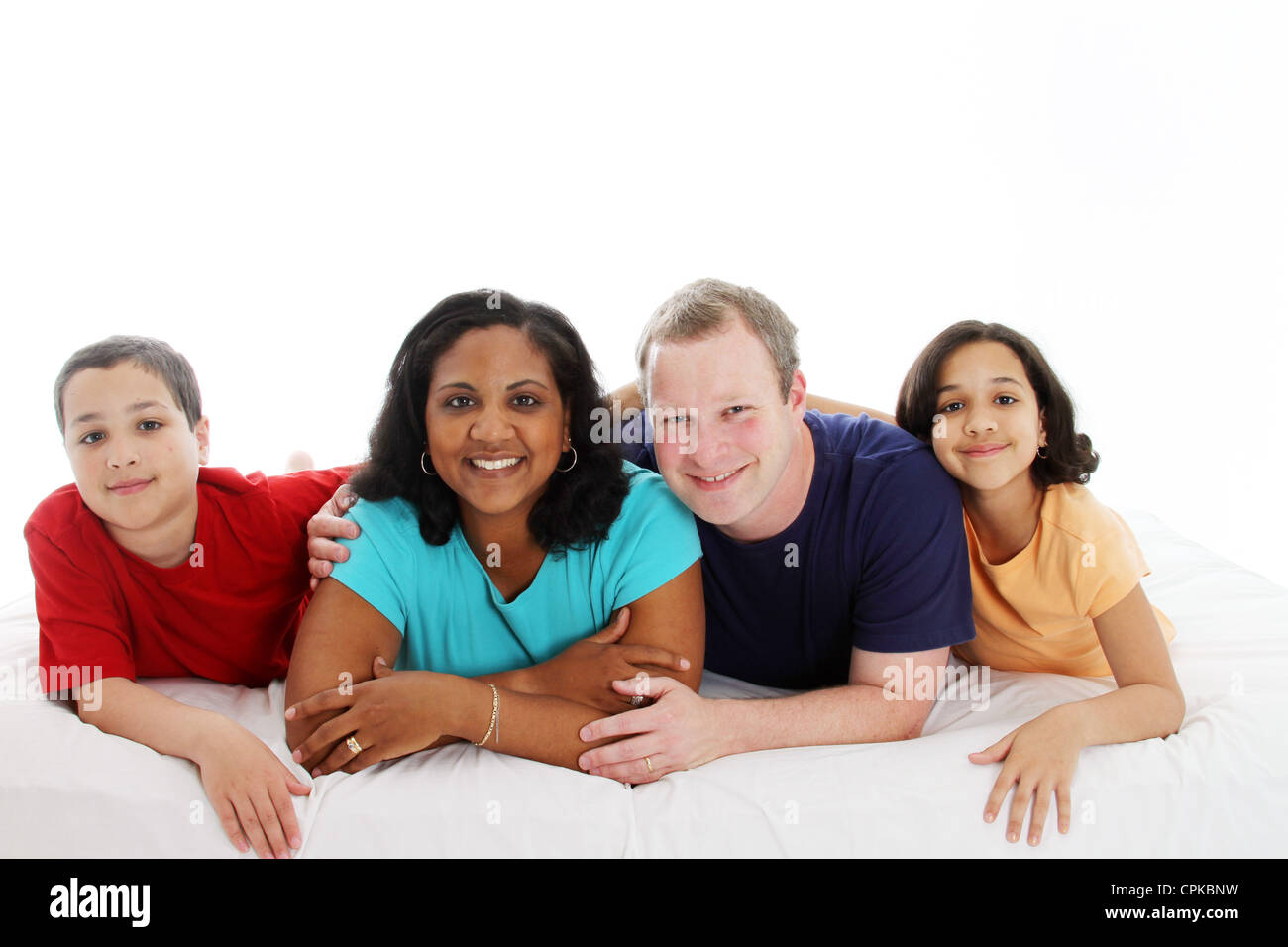 Family laying down together on a bed Stock Photo - Alamy