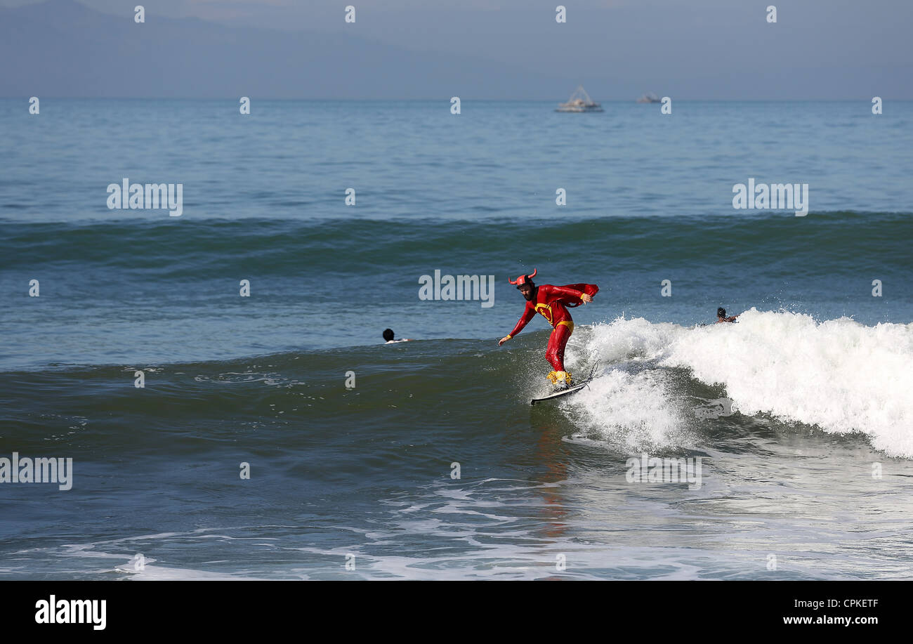 Man surfing in a superhero costume on a wave in Java Stock Photo - Alamy