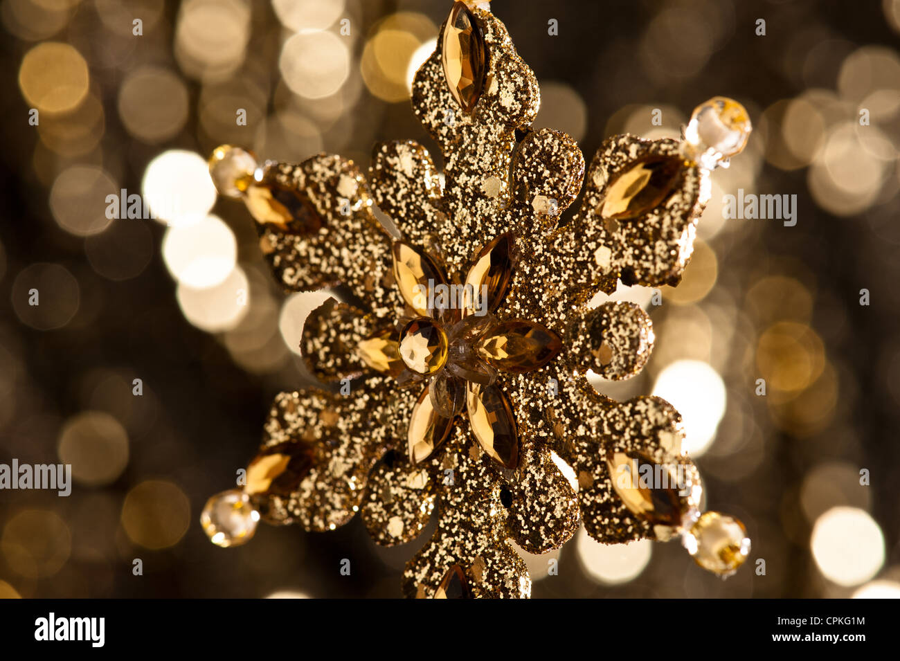 Artificial Snowflake in gold shining over a golden background Stock ...