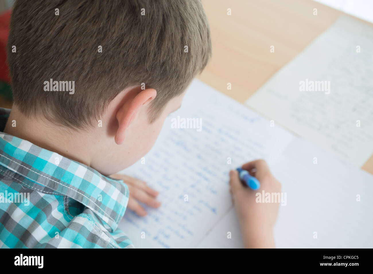 Young boy, 7 years old, writing and doing his homework Stock Photo - Alamy