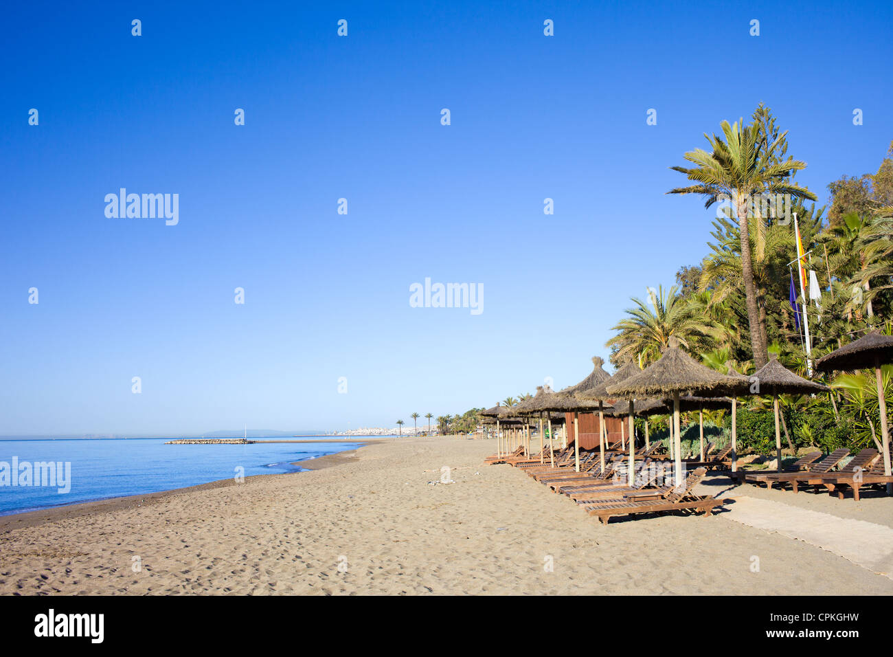Sun loungers on a sandy beach at the popular resort of Marbella in ...