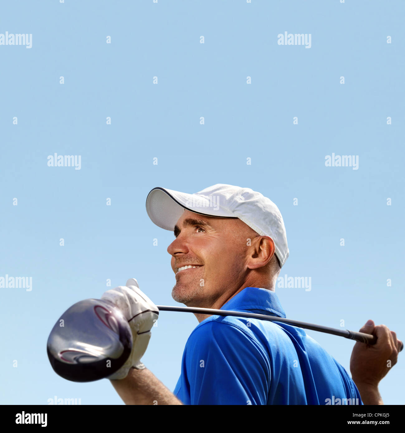 Smiling golfer holding golf club over shoulder Stock Photo - Alamy