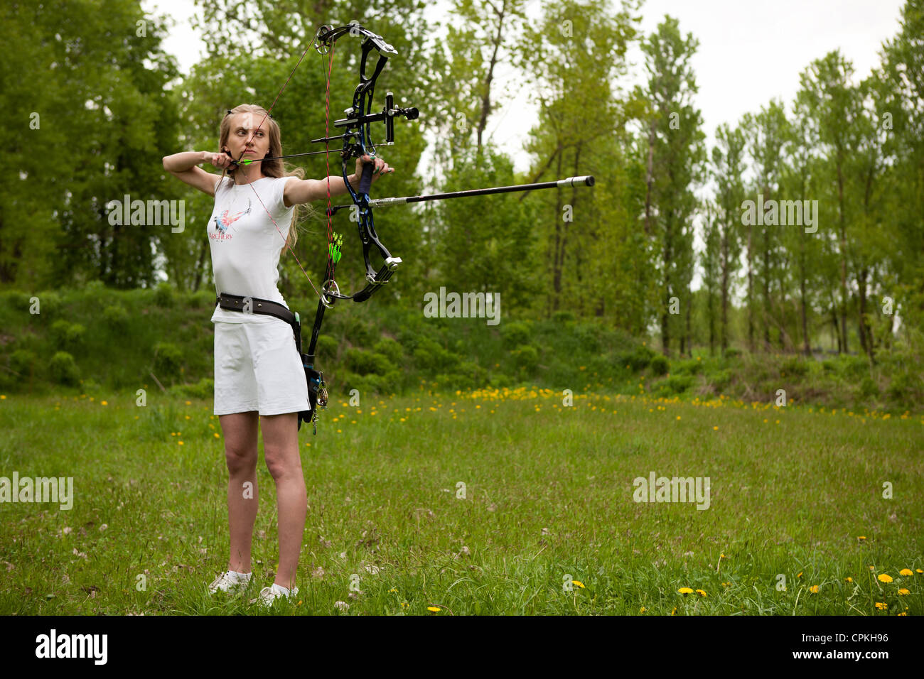 Female archer aiming at target Stock Photo - Alamy