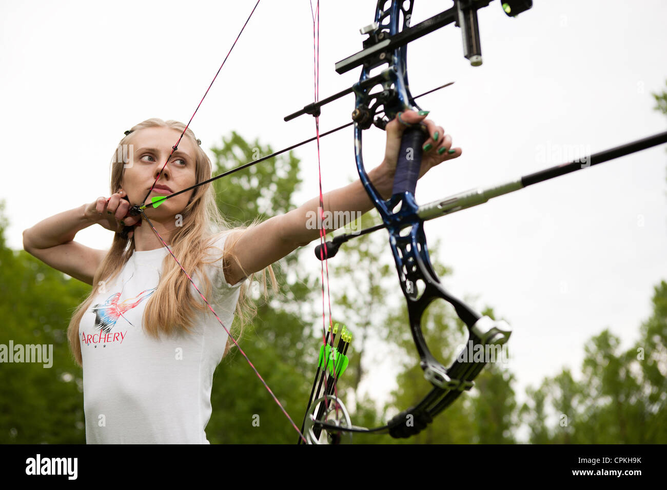Female archer aiming at target Stock Photo - Alamy