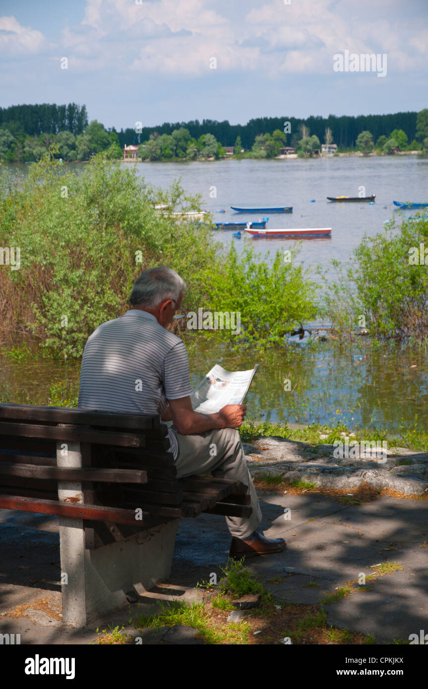 Man reading by River Danube along Zemunski kej riverside promenande ...