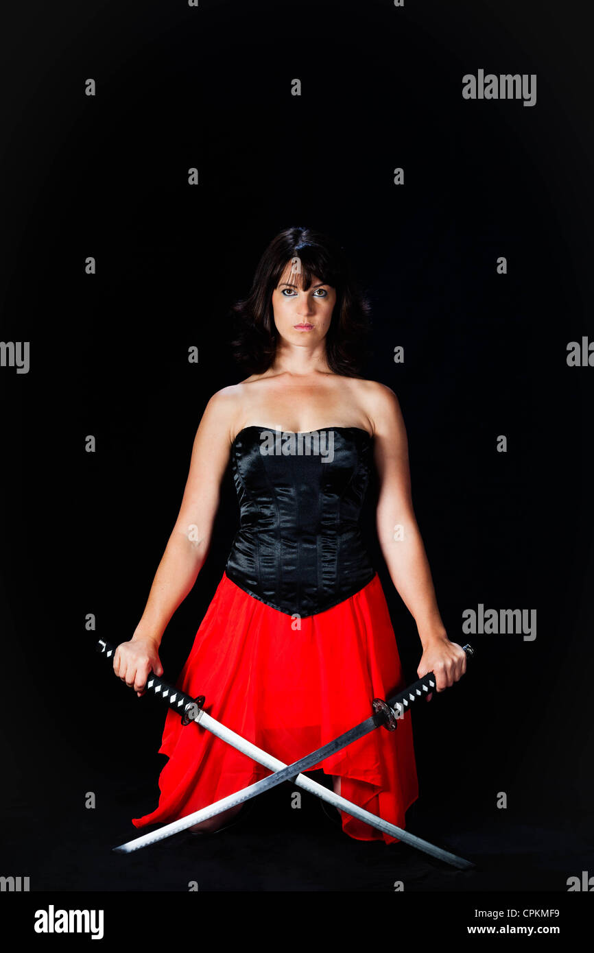Female assassin kneels with Katana sword Stock Photo - Alamy