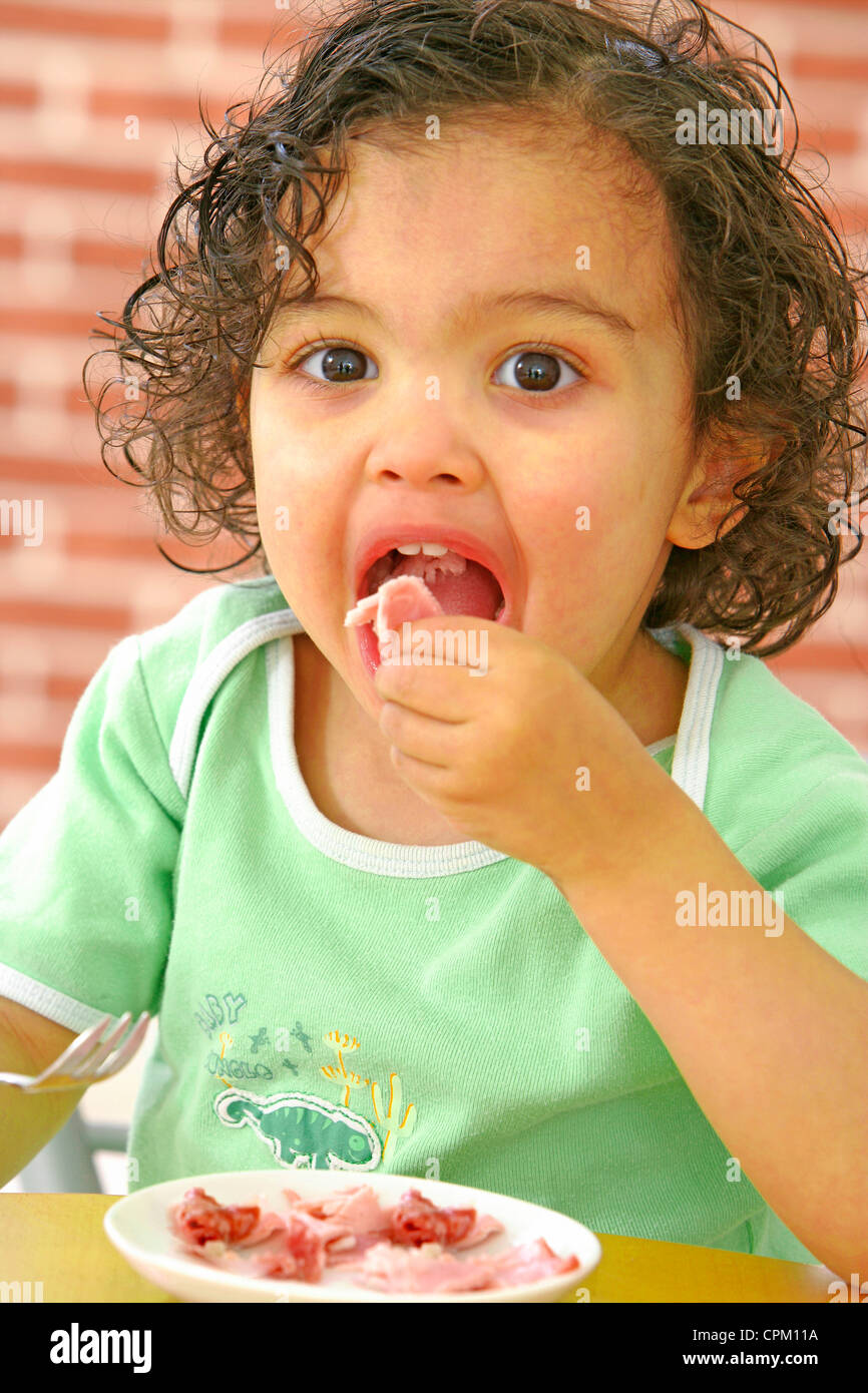 CHILD EATING PORK MEAT Stock Photo - Alamy