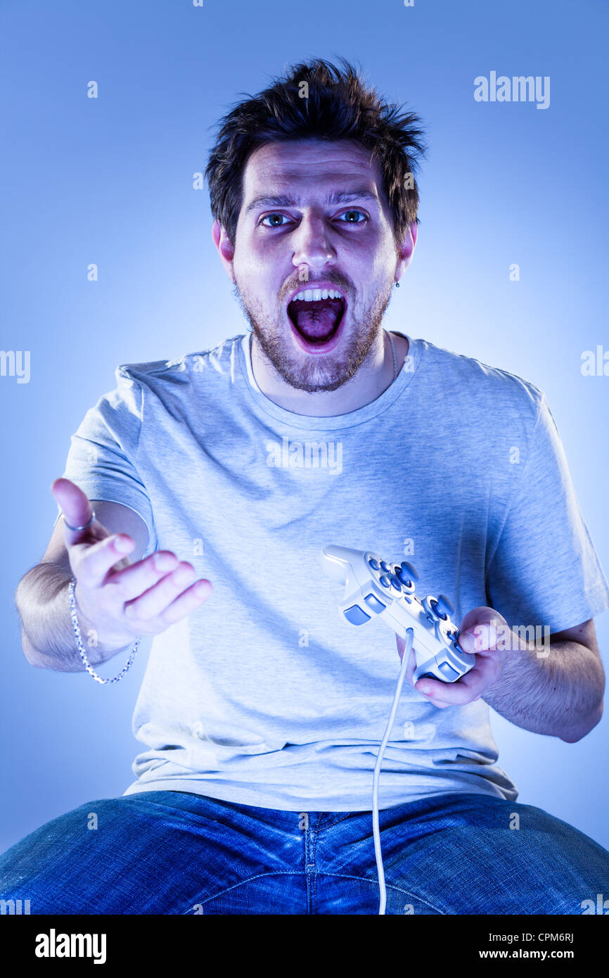 Shocked Man Playing Videogames with Gamepad Stock Photo - Alamy
