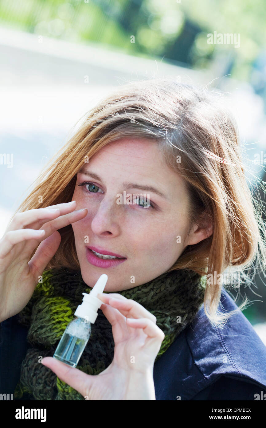 WOMAN USING NOSE SPRAY Stock Photo - Alamy