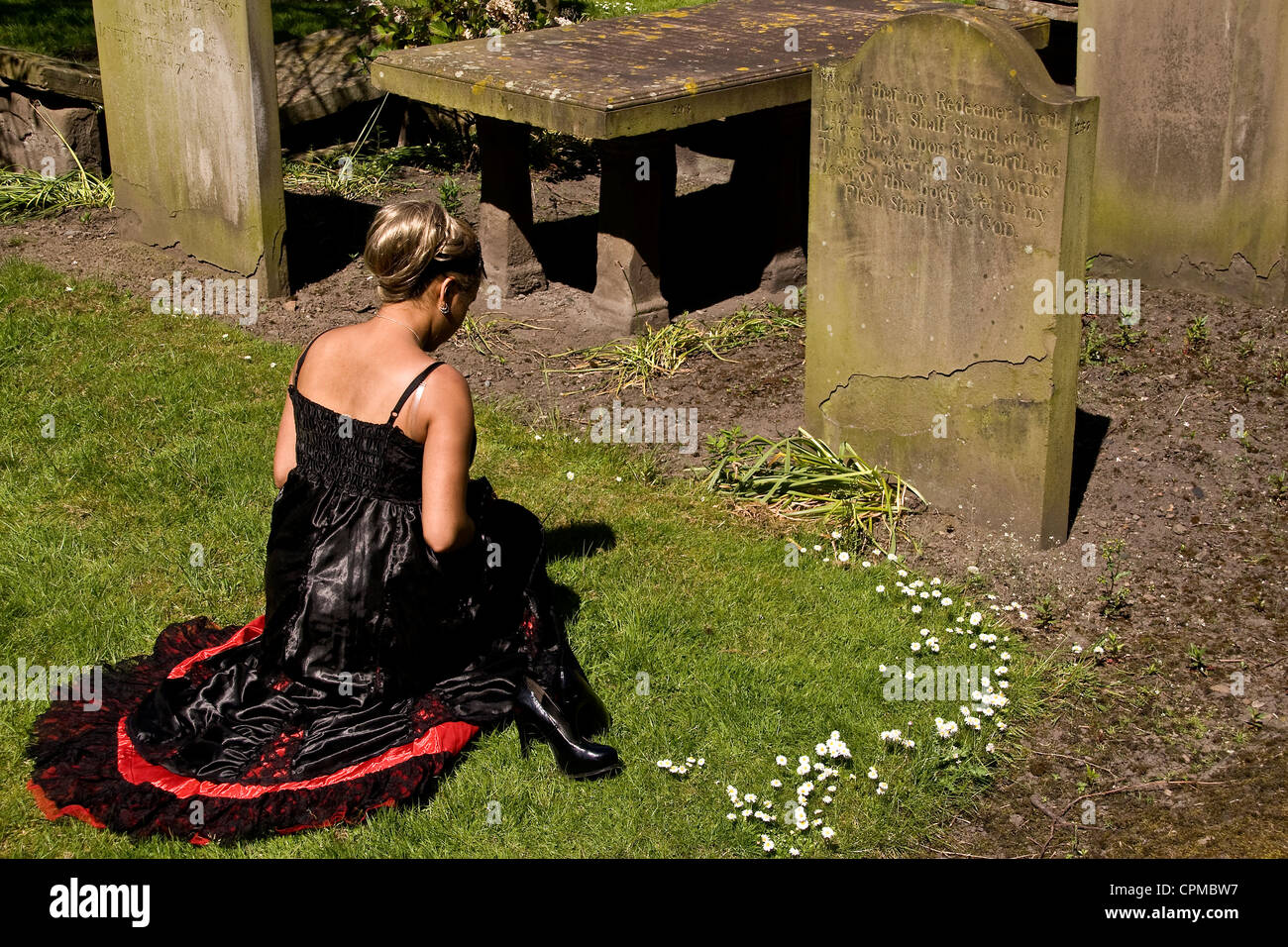 Glamorous Gothic girl kneeling beside old gravestones at the Howff ...
