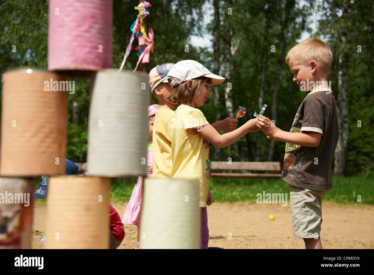 Children throw with small ball on pyramid of cans Stock Photo - Alamy