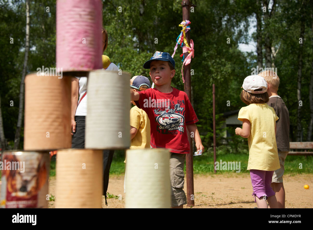 Children throw with small ball on pyramid of cans Stock Photo - Alamy