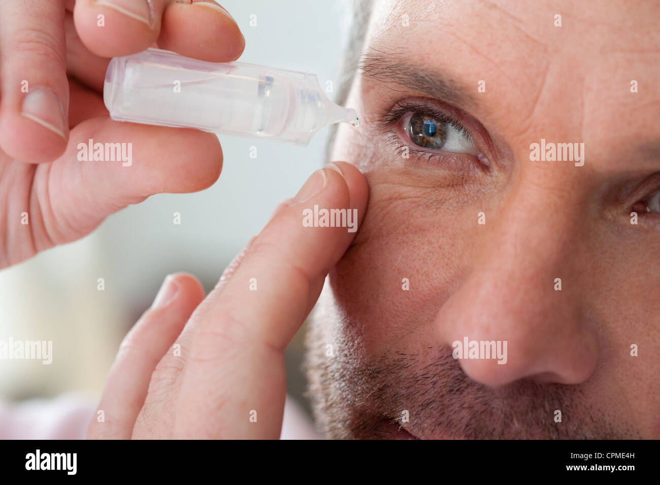MAN USING EYE LOTION Stock Photo - Alamy