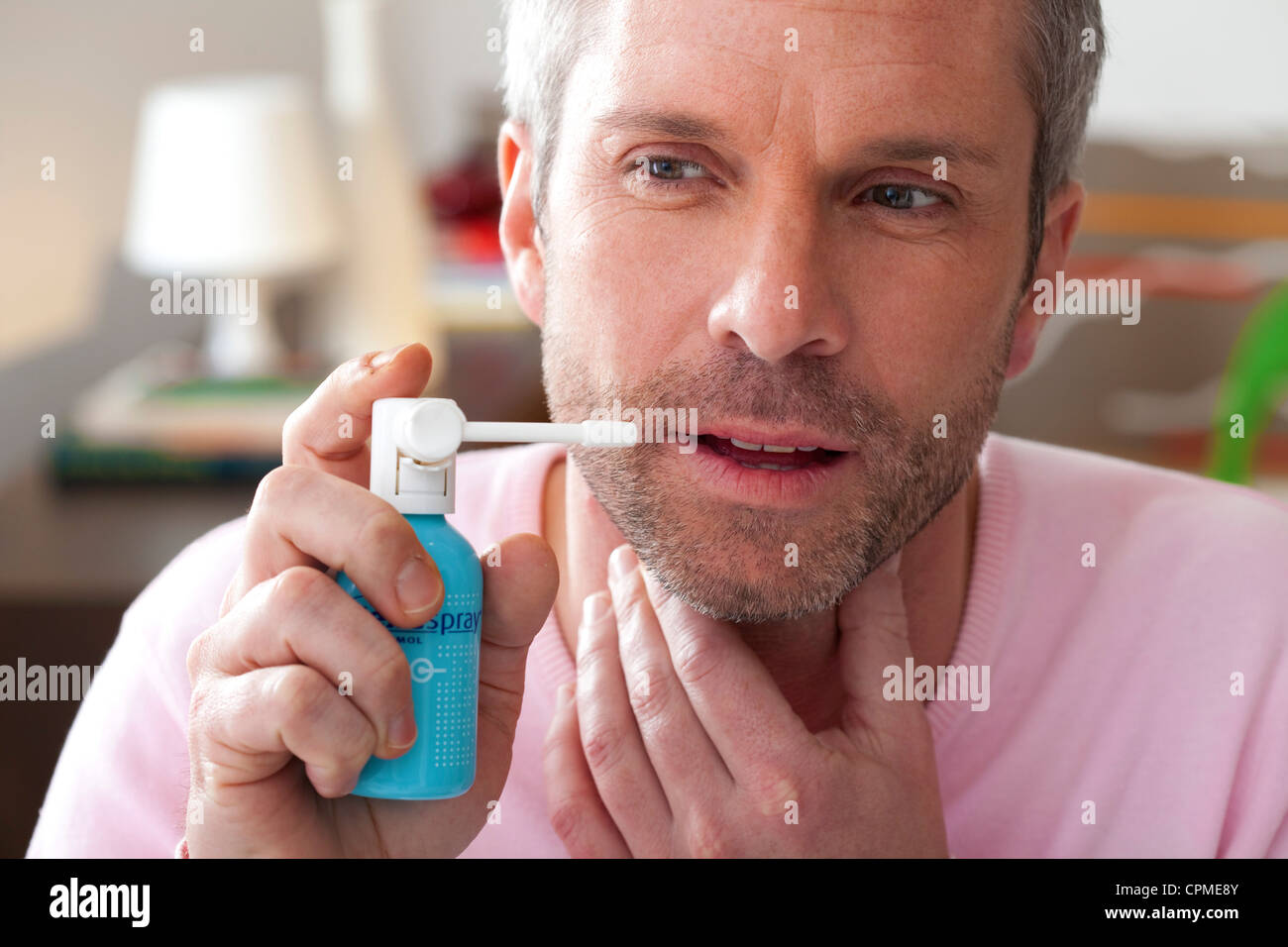 MAN USING MOUTH SPRAY Stock Photo - Alamy