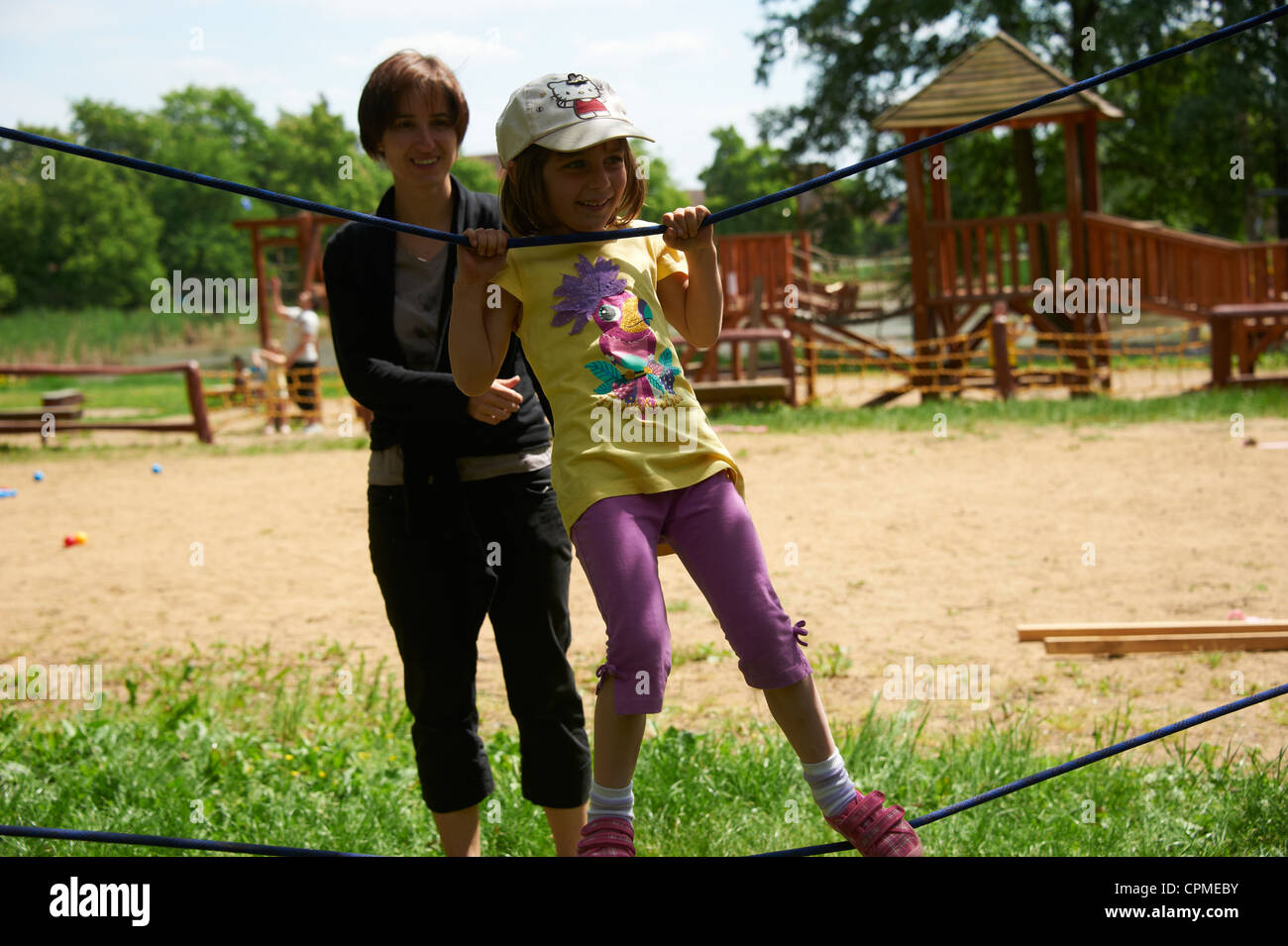 children training and walking on rope - slacline with mother summer ...